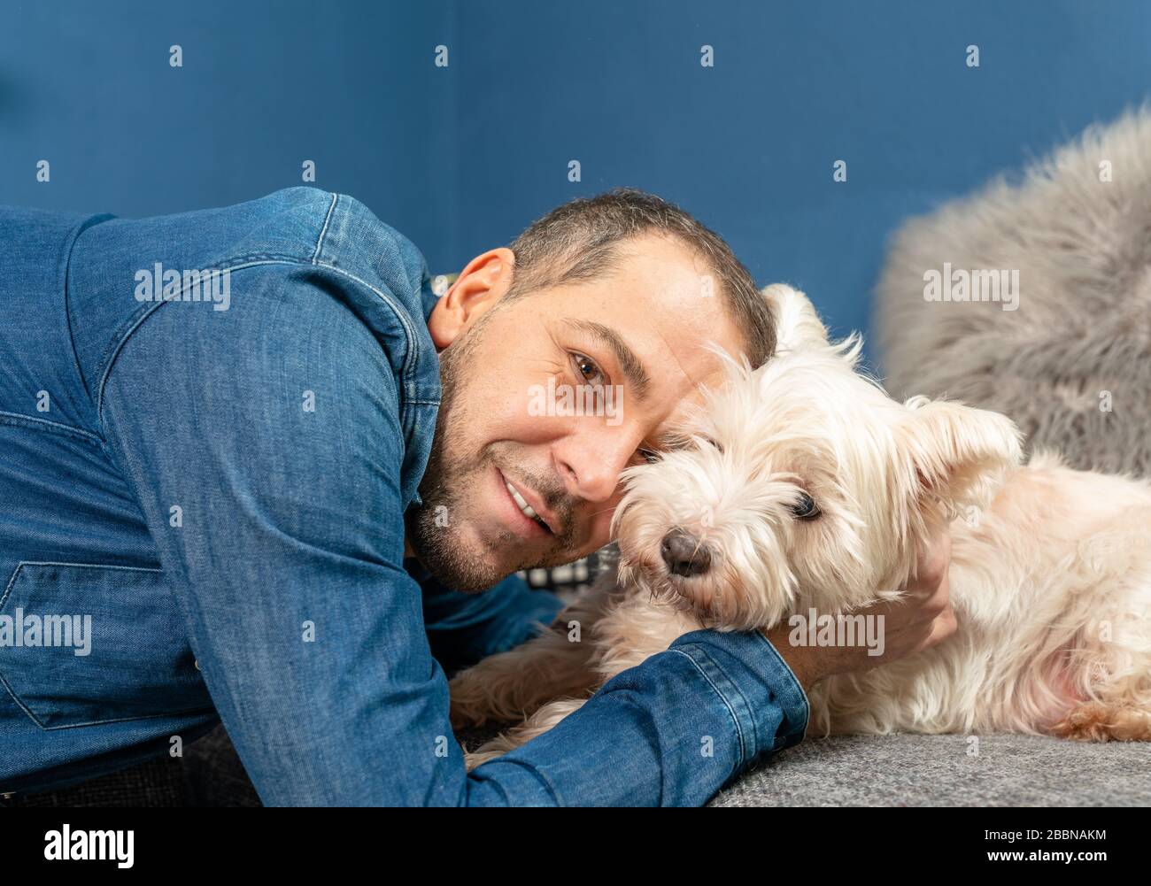 A man cuddles with his dog on the couch Stock Photo - Alamy