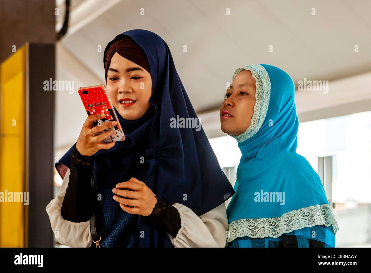 Two Young Women Looking At A Smart Phone (Cell Phone), The Metro (MRT ...
