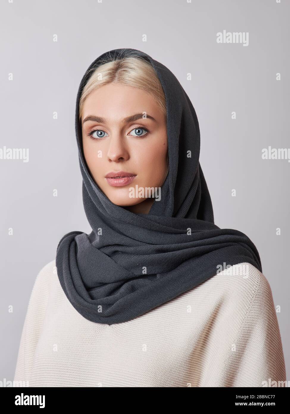 European Muslim woman with a blonde hair in a headscarf shawl dressed ...