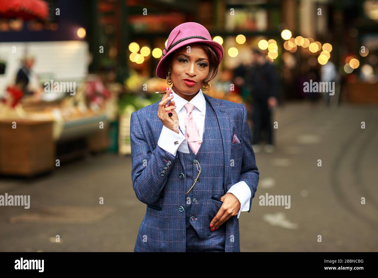 a young woman dressed in a tweed suit smoking Stock Photo - Alamy