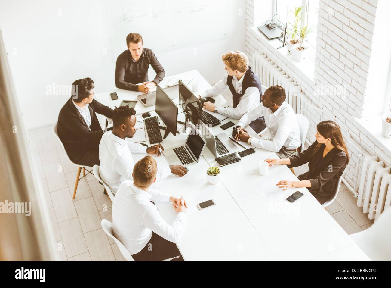 A team of young businessmen working and communicating together in an ...