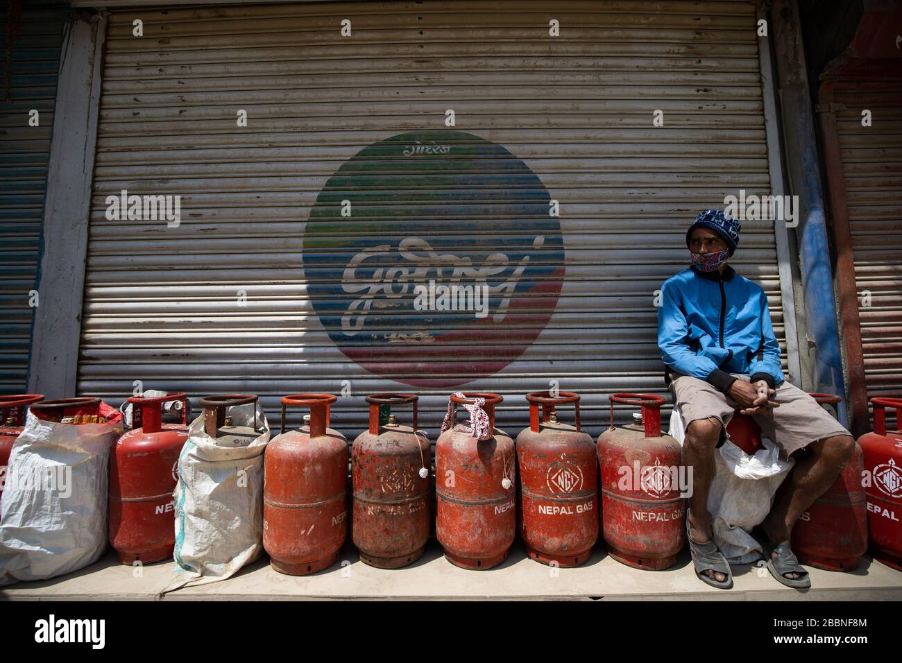 A man wearing a face mask as a preventive measure, seats on LPG ...