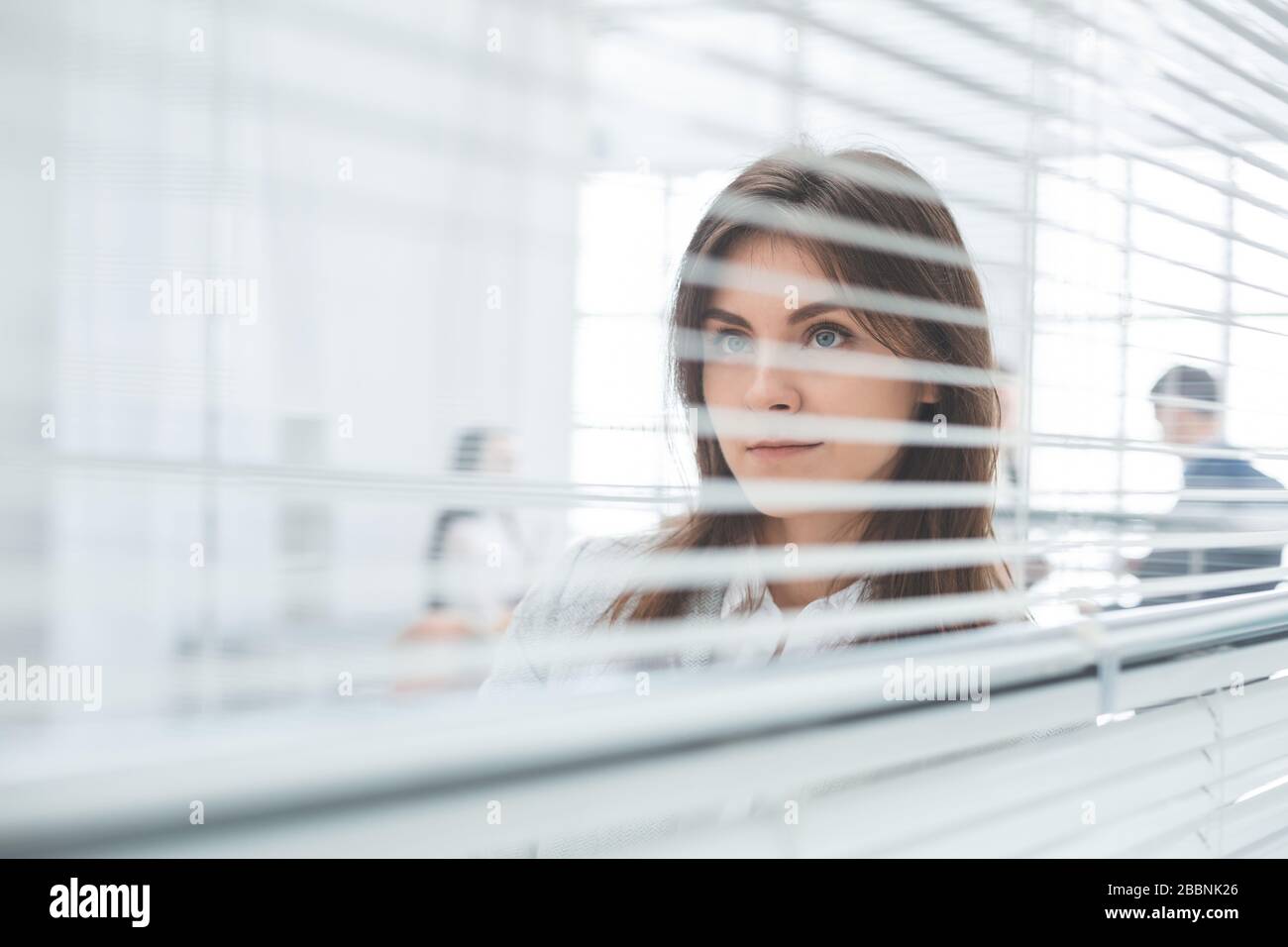 young business woman looking through office window Stock Photo - Alamy