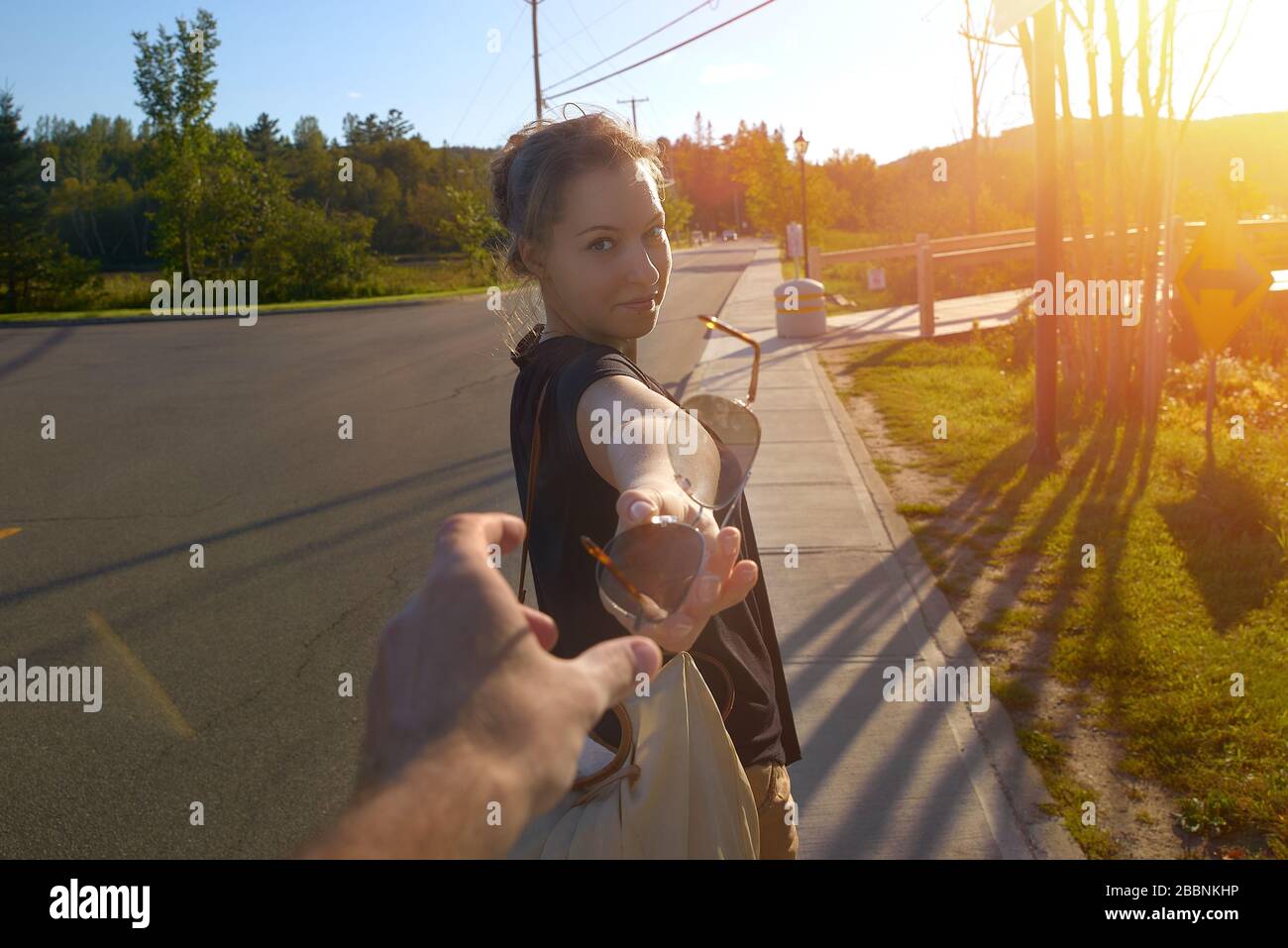 Follow me - happy young woman pulling guy's hand - hand in hand walking ...