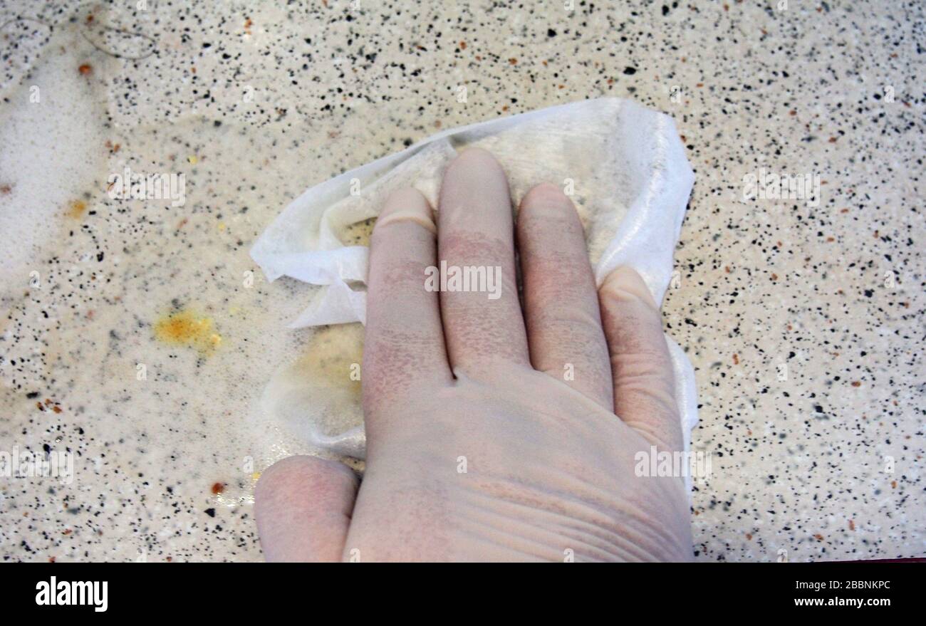Cleaning the table surface with a detergent and paper napkin ...