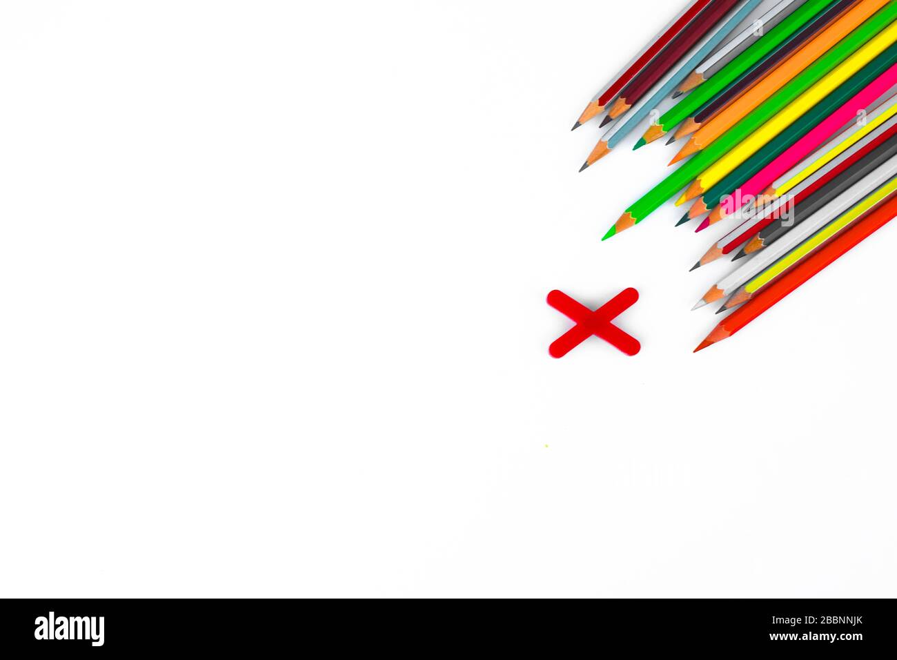 Row of different colored wood pencil crayon pointing at a red colored X ...