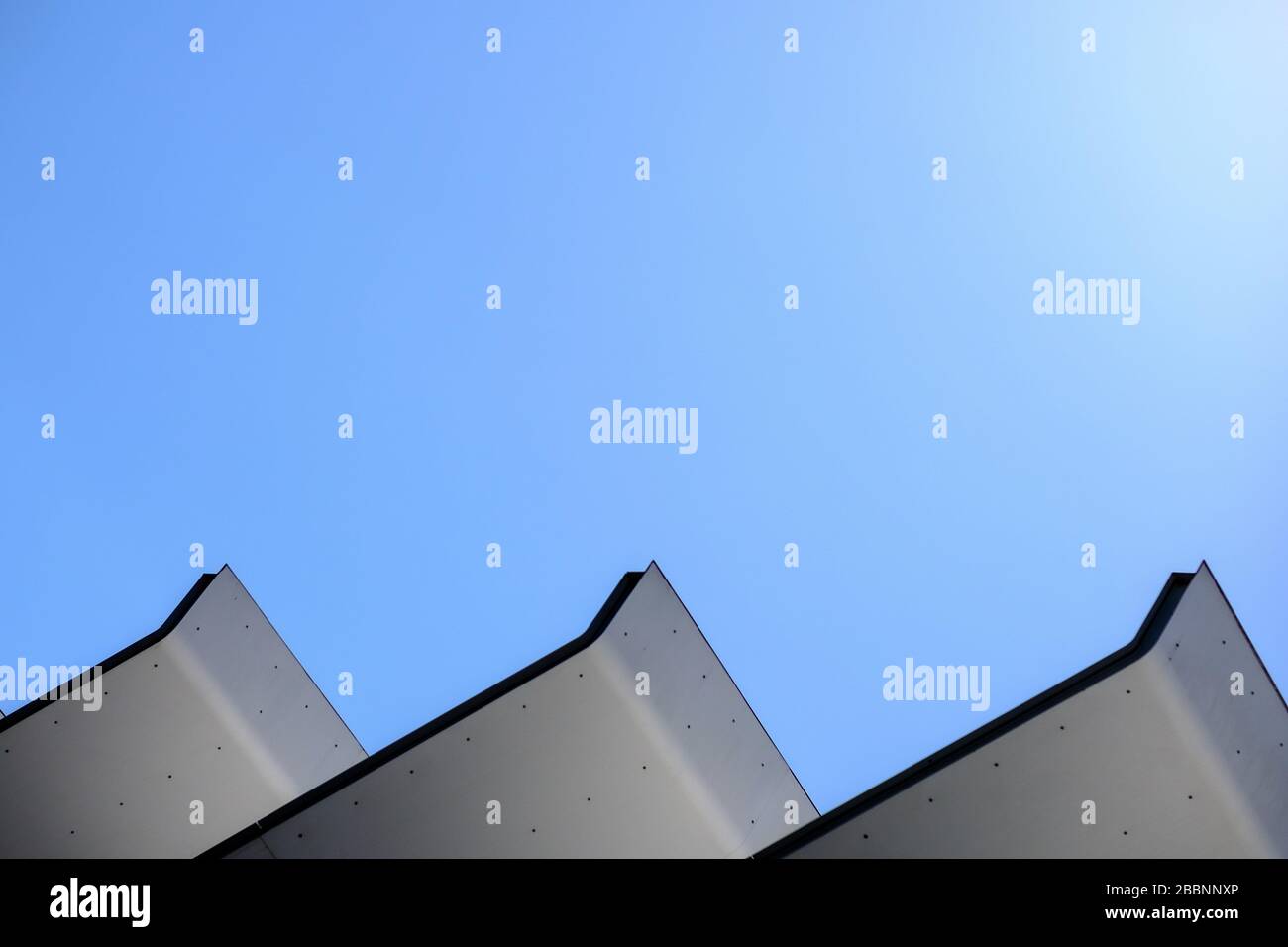 A strong contrast between the man made roof structure and a clear blue ...