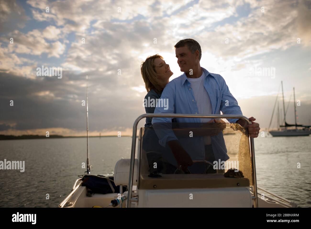 Mid-adult woman with her arms around her mature husband as they cruise ...