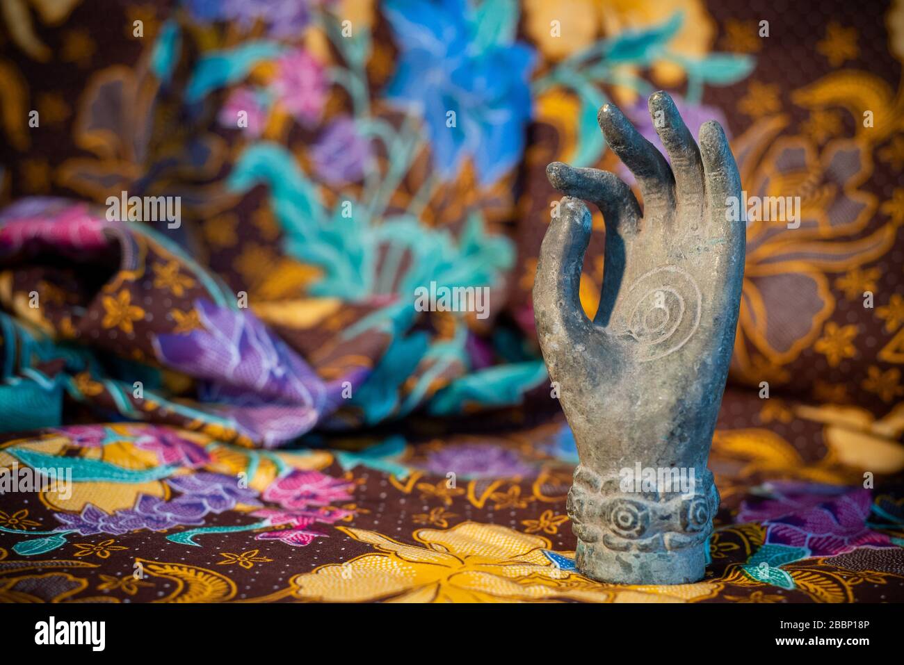 Buddha hand and patterned batik Stock Photo - Alamy