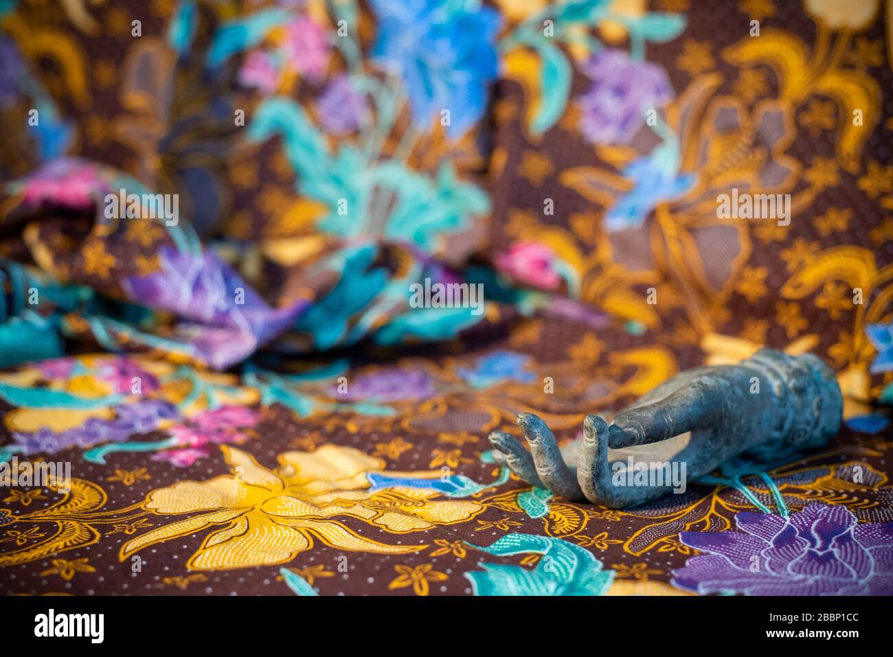 Buddha hand and patterned batik Stock Photo - Alamy