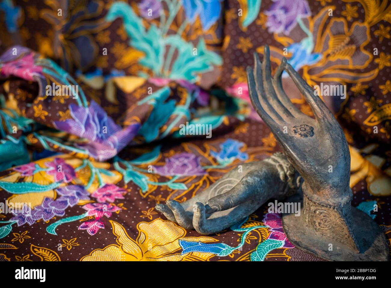 Buddha hand and patterned batik Stock Photo - Alamy