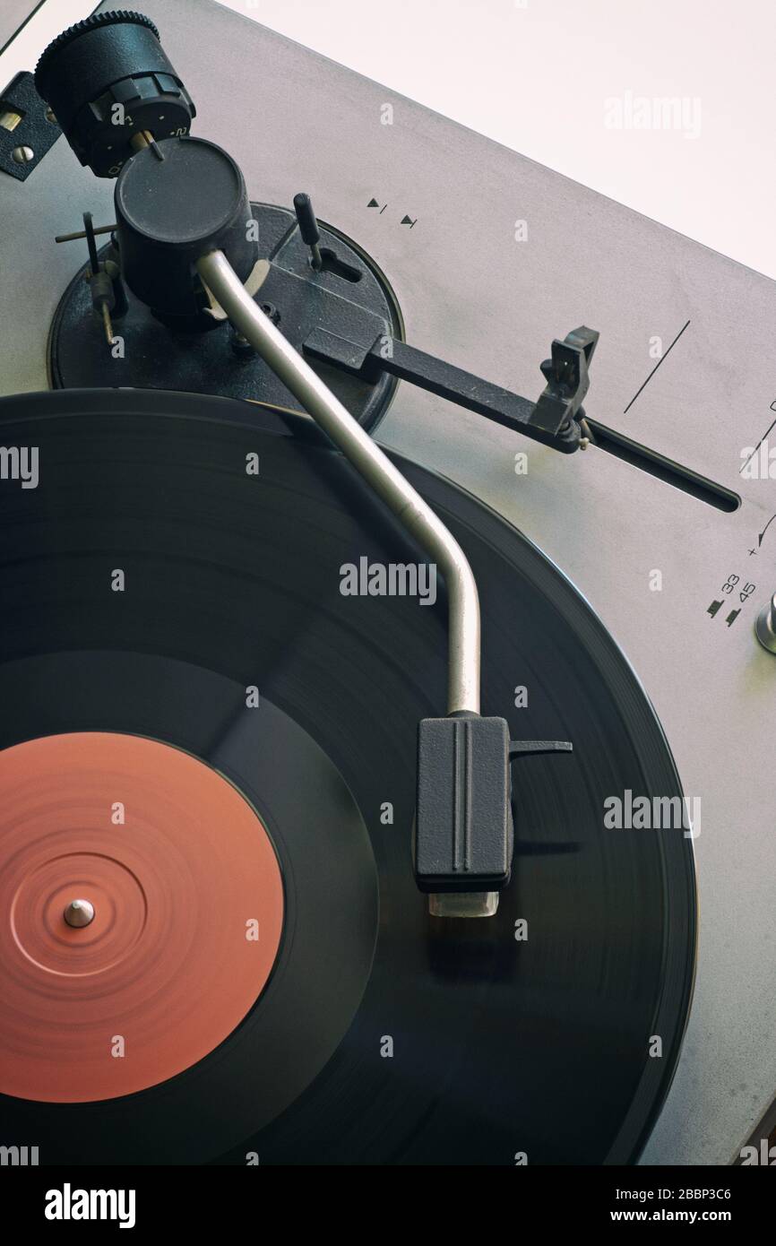 The stylus of the vinyl analog player is in contact with the surface of ...
