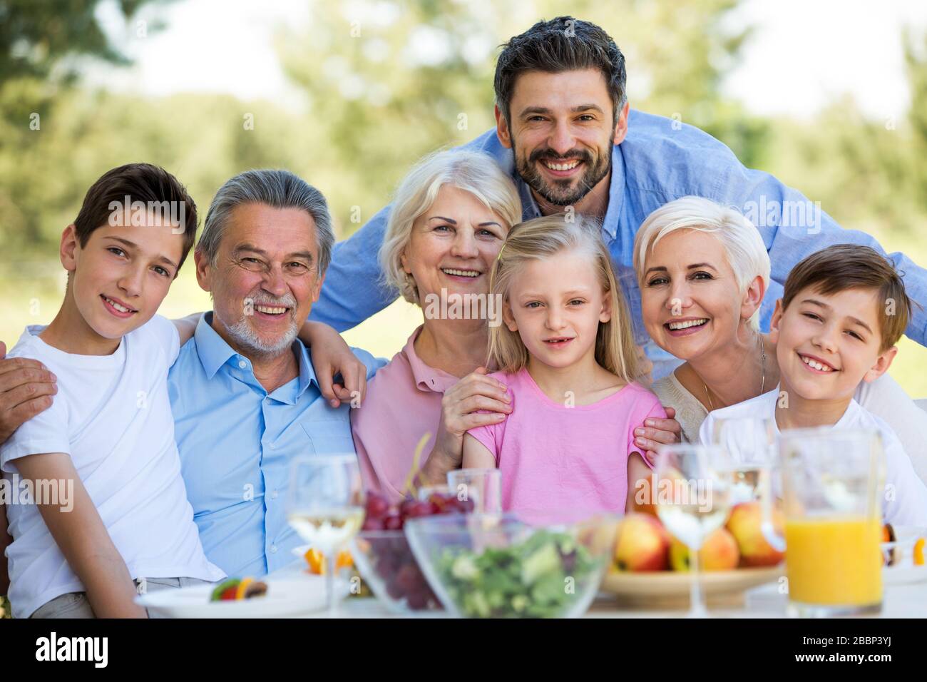 Family sitting having lunch in garden Stock Photo - Alamy
