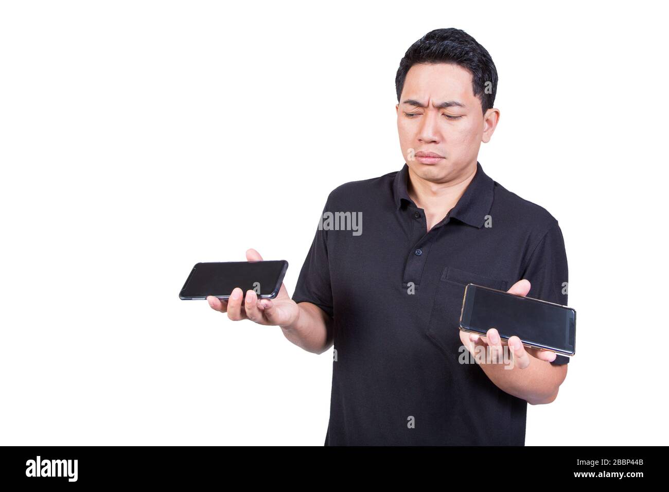man holding two mobile phone in hand serious face trouble choice ...