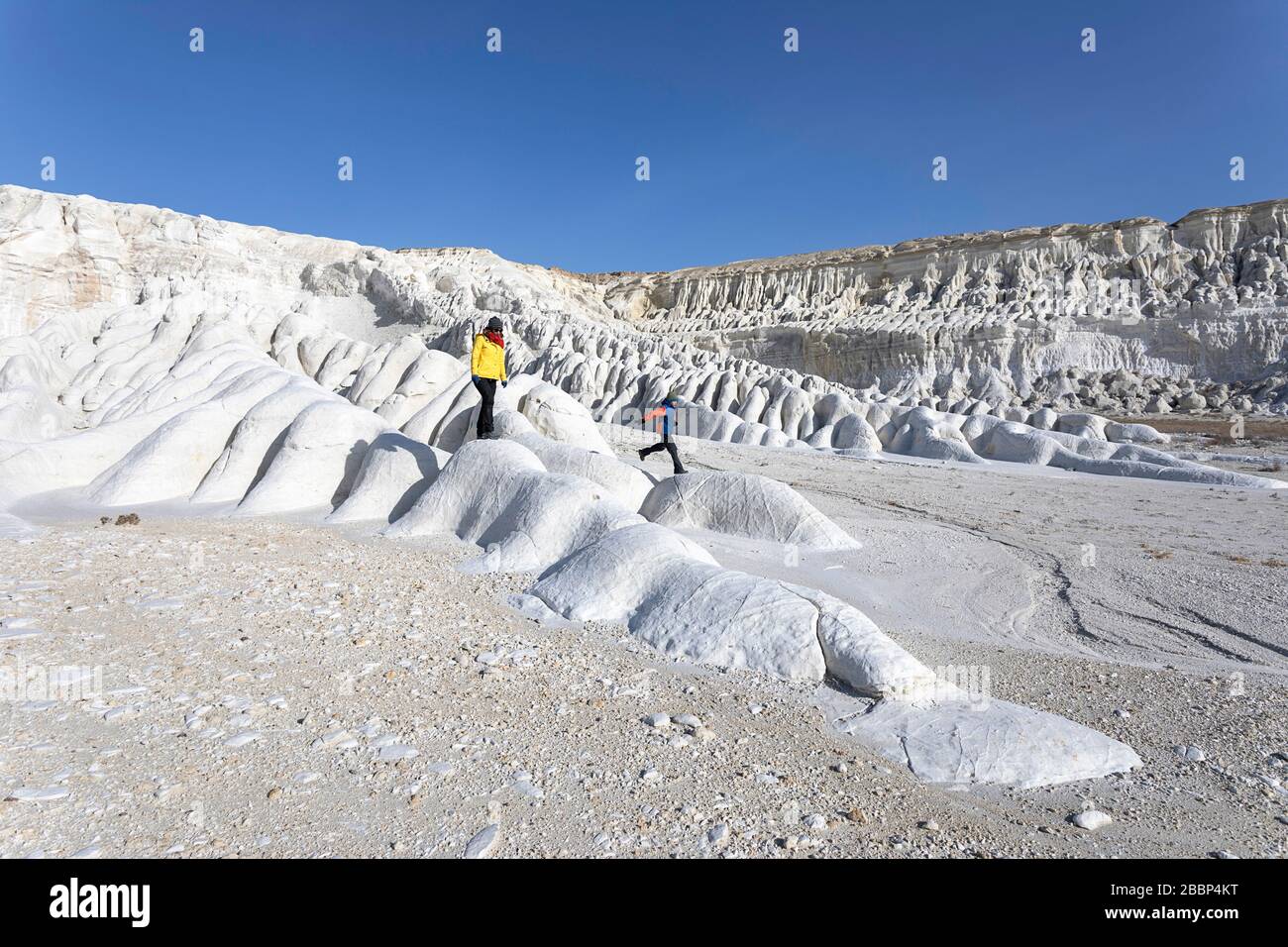 Mother and son climbing the rock formations in the dramatic landscape ...