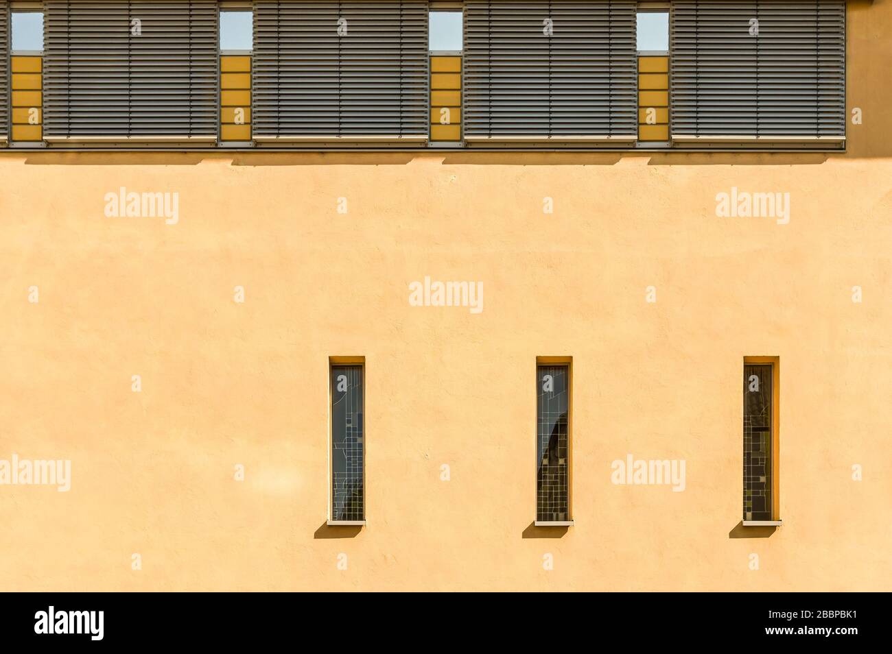 Detail Modern facade of a church with three narrow high mosaic windows ...