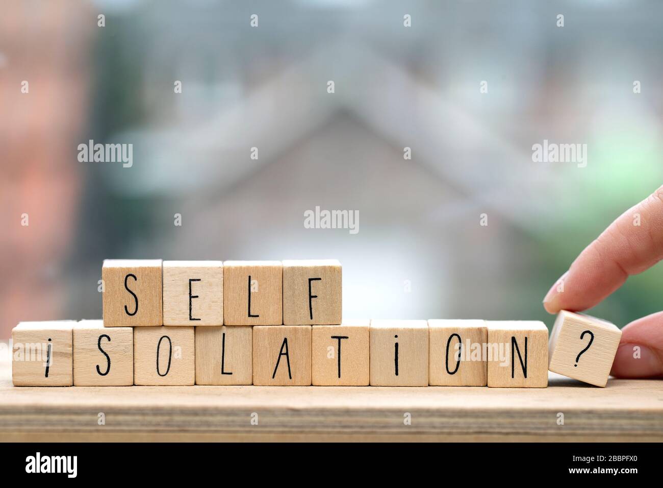 Wooden cubes with the word Self isolation and a question mark for Covid ...