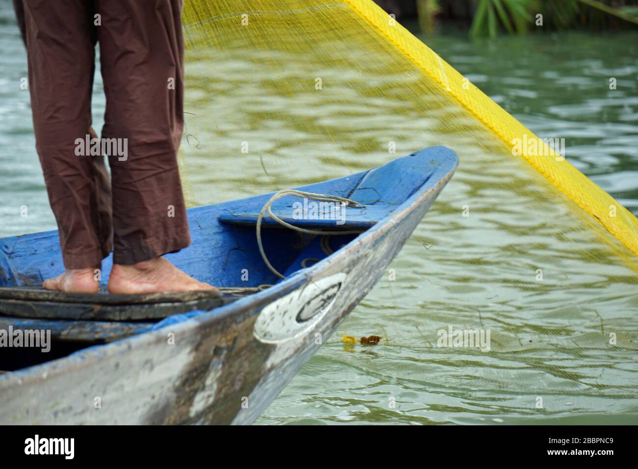 vietnamese fisherman on small boat fishing with fishnet Stock Photo - Alamy