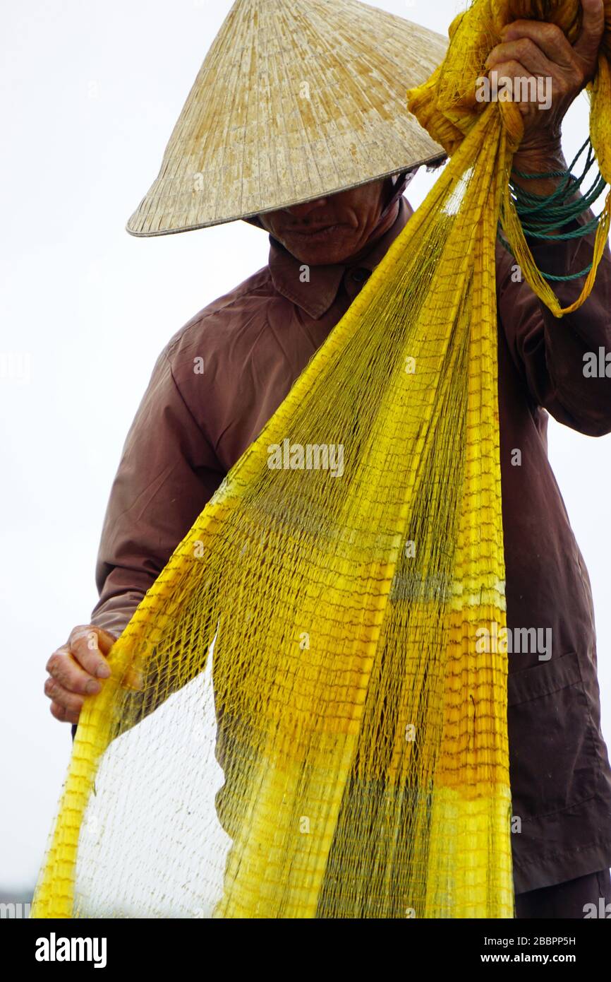 vietnamese fisherman on small boat fishing with fishnet Stock Photo - Alamy