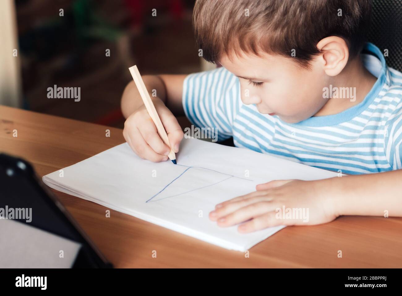 Modern child uses app on tablet to study and draw at home, distance ...