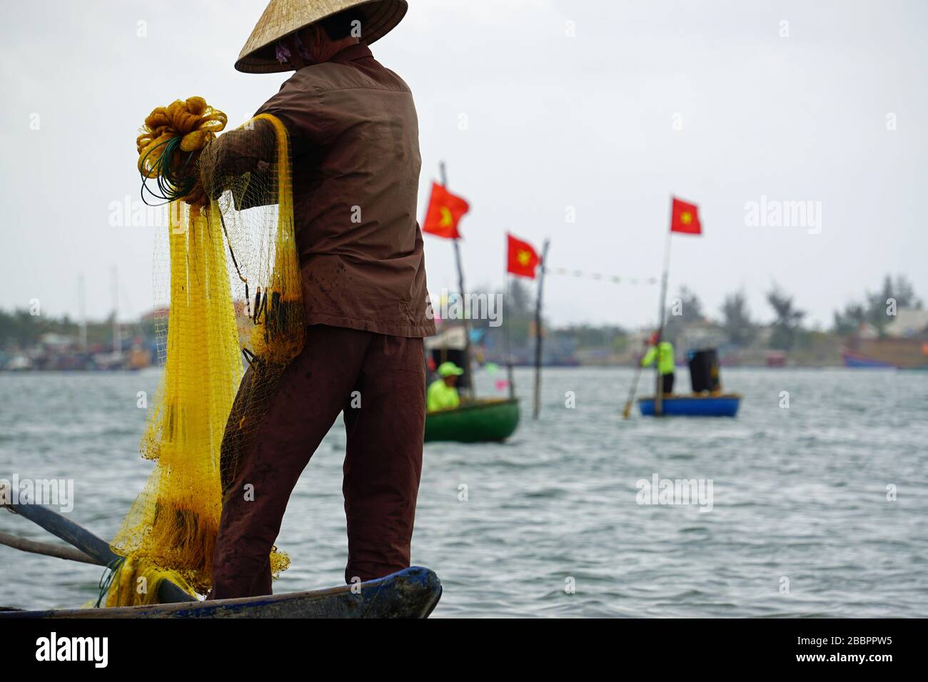 vietnamese fisherman on small boat fishing with fishnet Stock Photo - Alamy