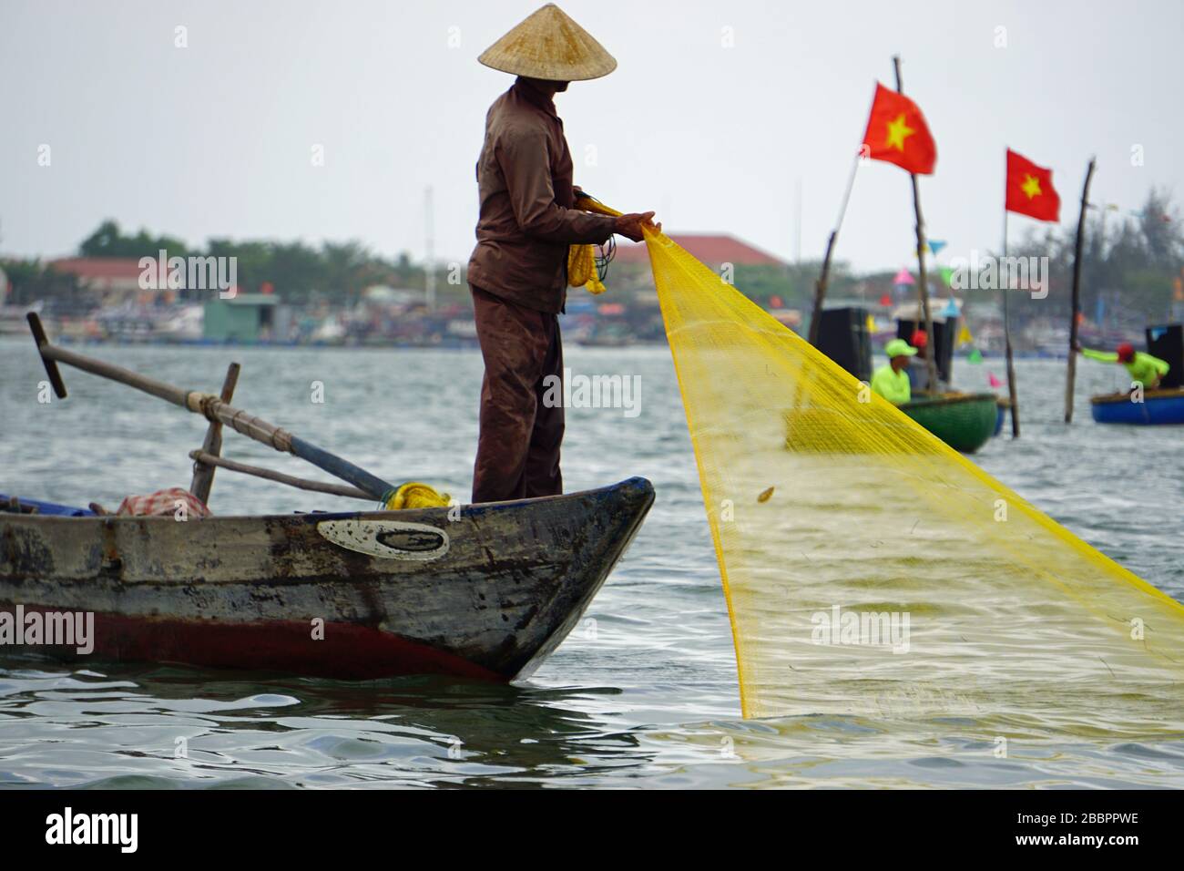 vietnamese fisherman on small boat fishing with fishnet Stock Photo - Alamy