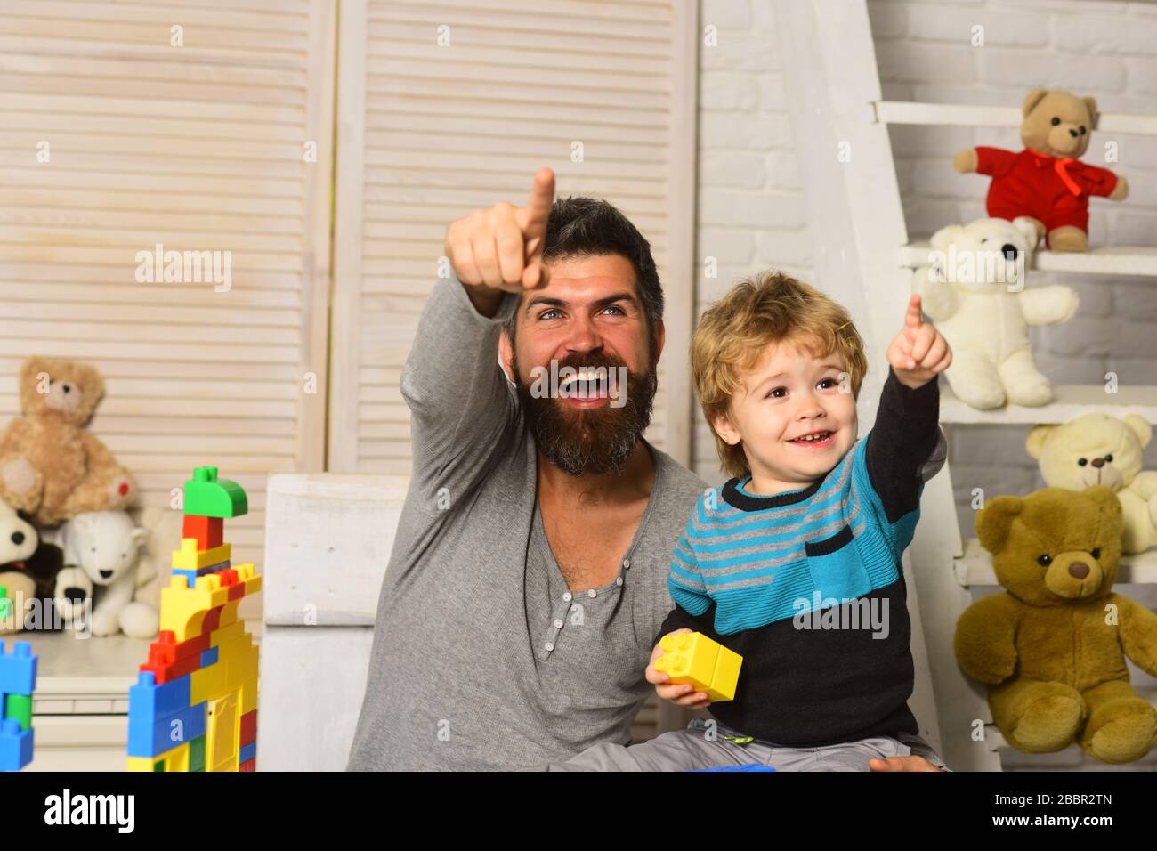 Dad and kid with toys on background build of plastic blocks. Family and ...