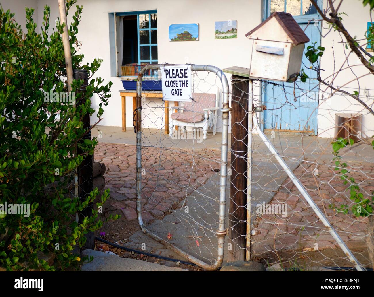 Metal wire gate fence, with sign "please close the gate" but gate in ...