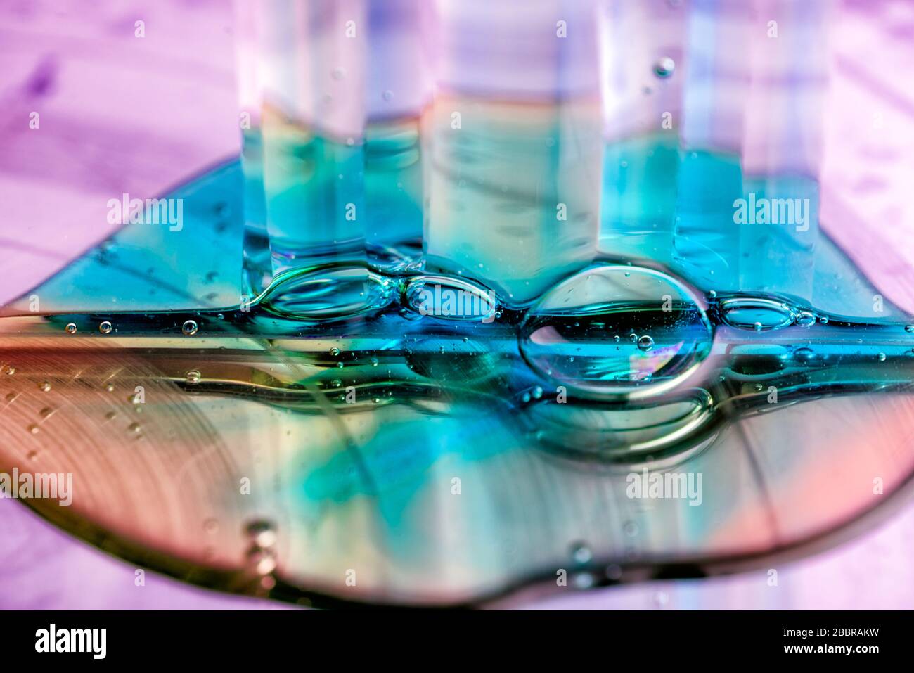 Colorful translucent liquid with air bubbles dripping on transparent ...