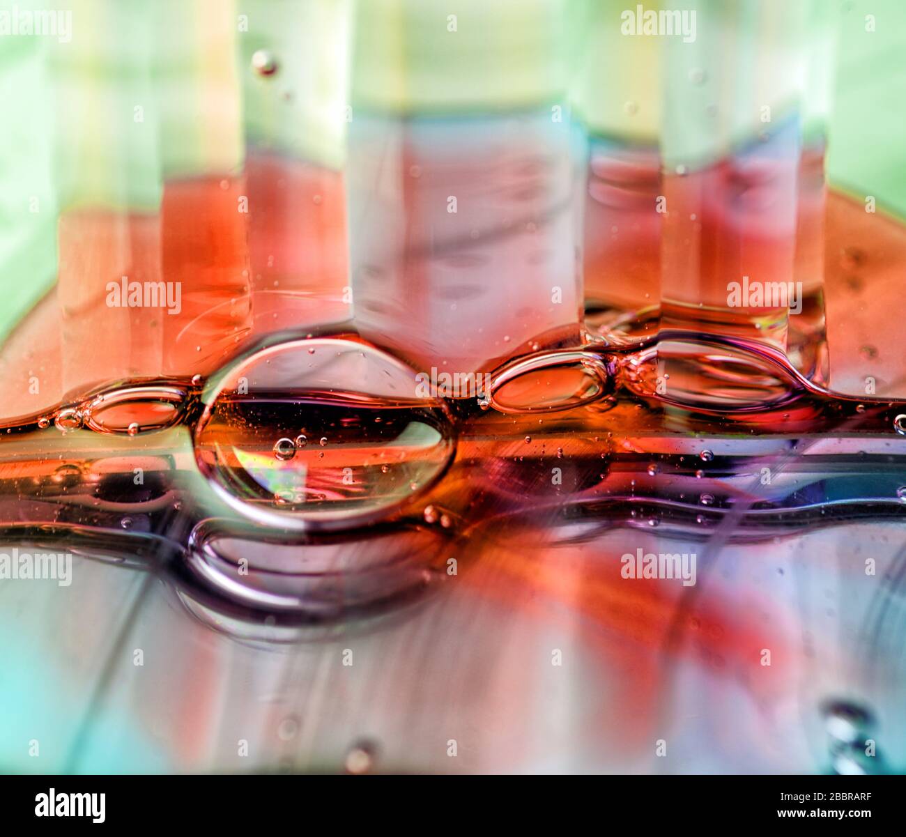 Colorful translucent liquid with air bubbles dripping on transparent ...