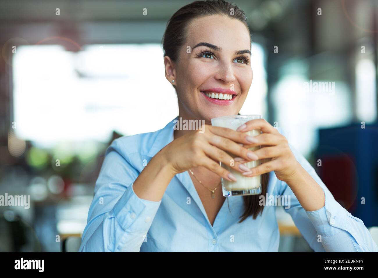 Woman drinking latte macchiato at cafe Stock Photo - Alamy