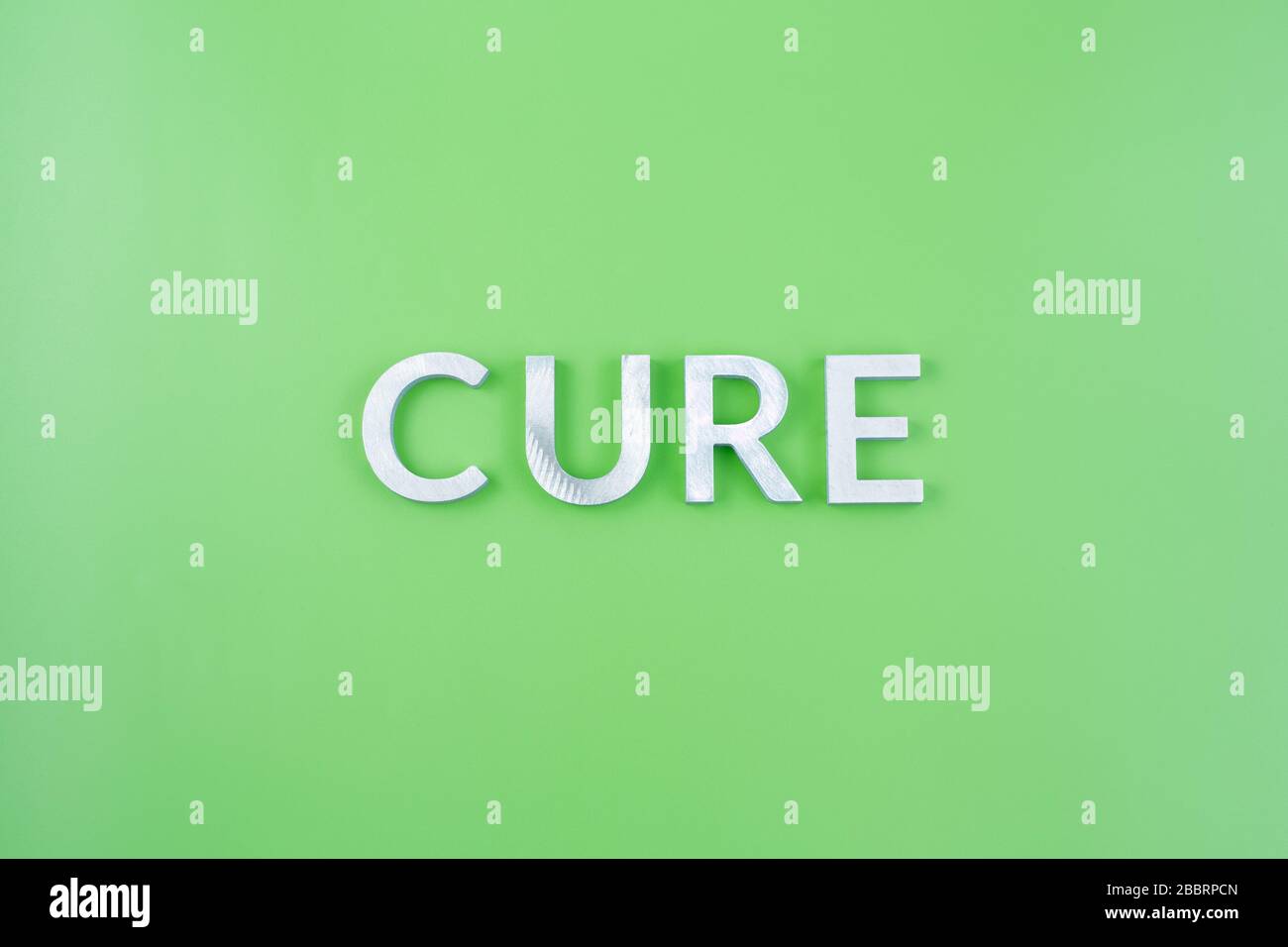 the word cure laid with thick aluminium letters on green background in ...