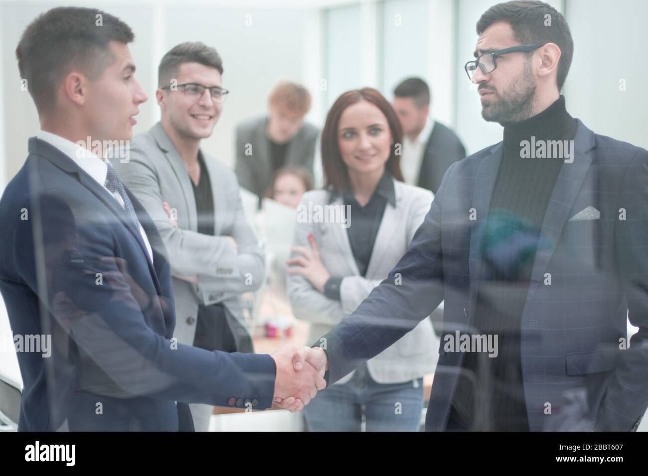 through the glass. business people shaking hands with each other Stock ...