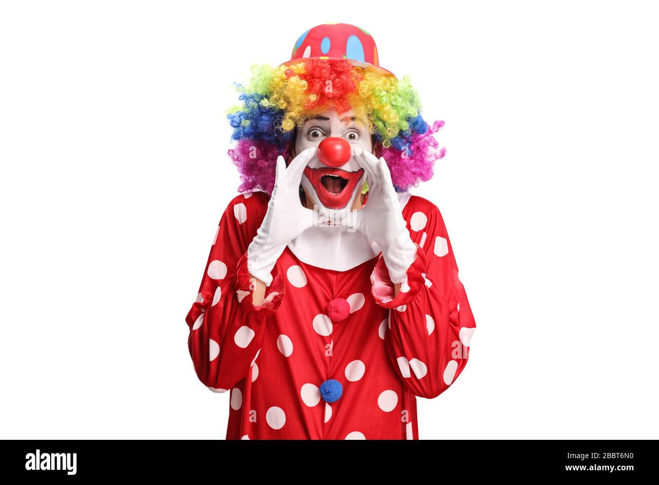 Clown in a polka dot red costume shouting isolated on white background ...