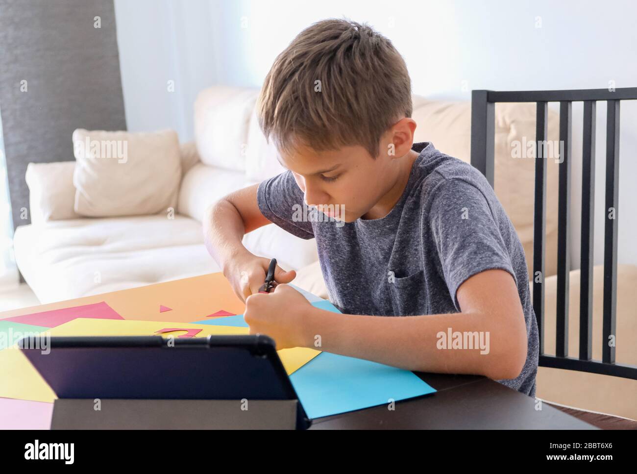 Education, paper crafts for kids. Child cutting colored paper with ...