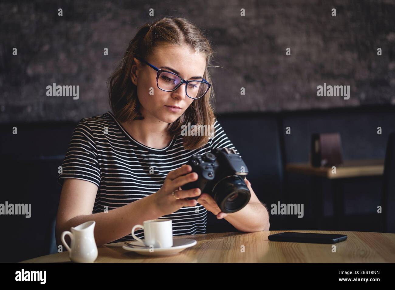 Young woman photographing chimping her photos Stock Photo - Alamy