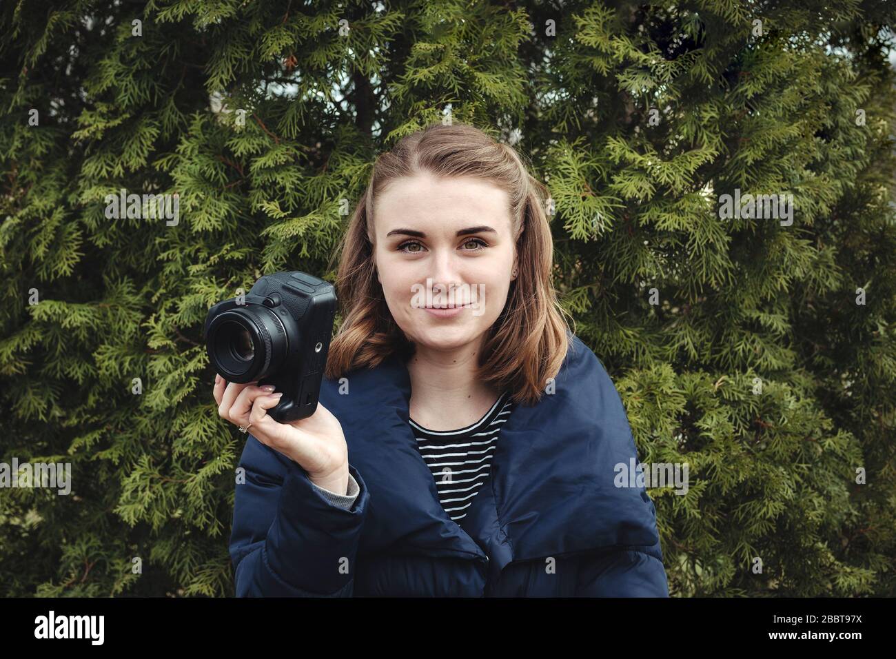 Attractive smiling photographer holding her camera Stock Photo - Alamy