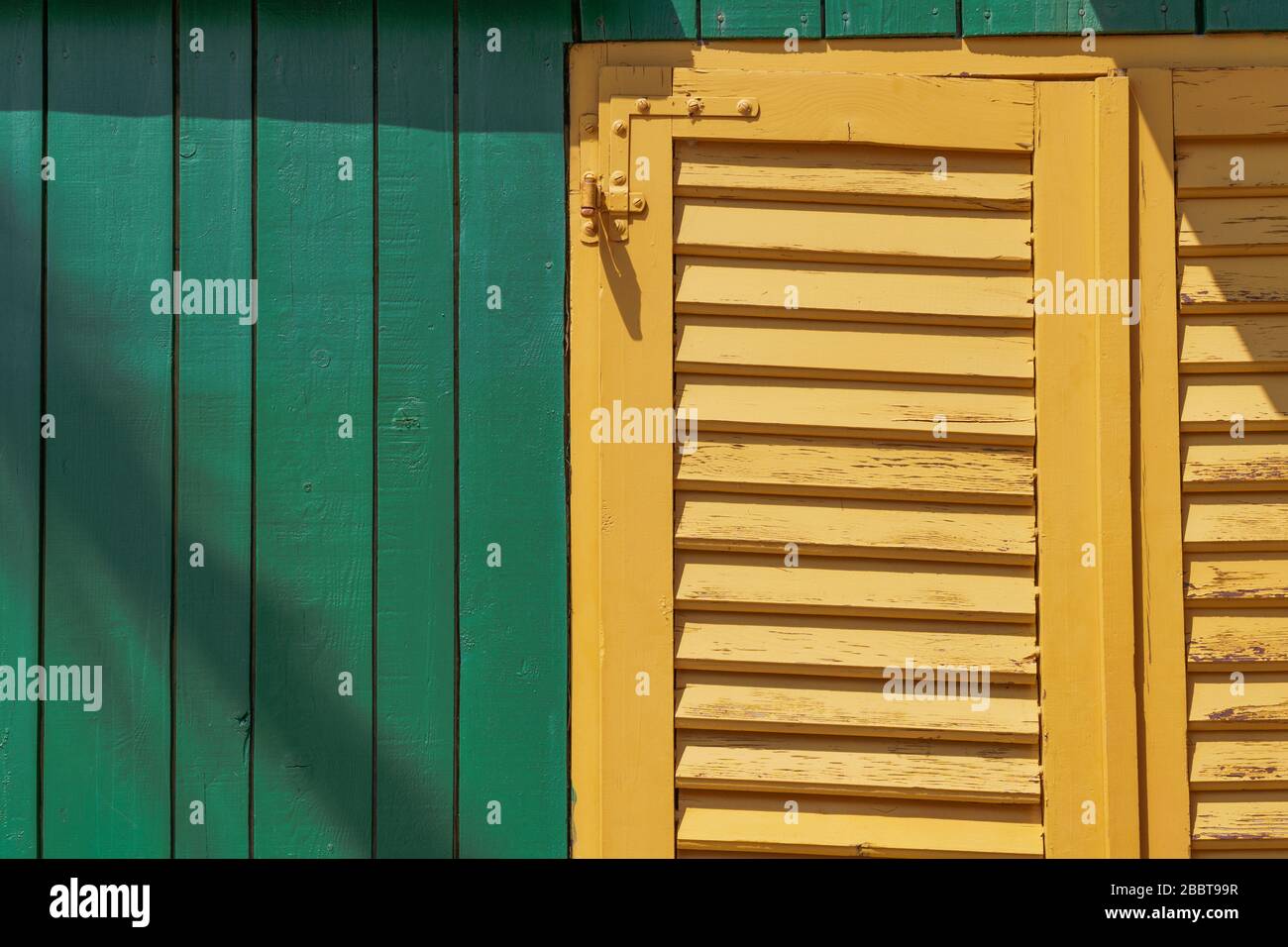 a yellow window on a green shed Stock Photo - Alamy