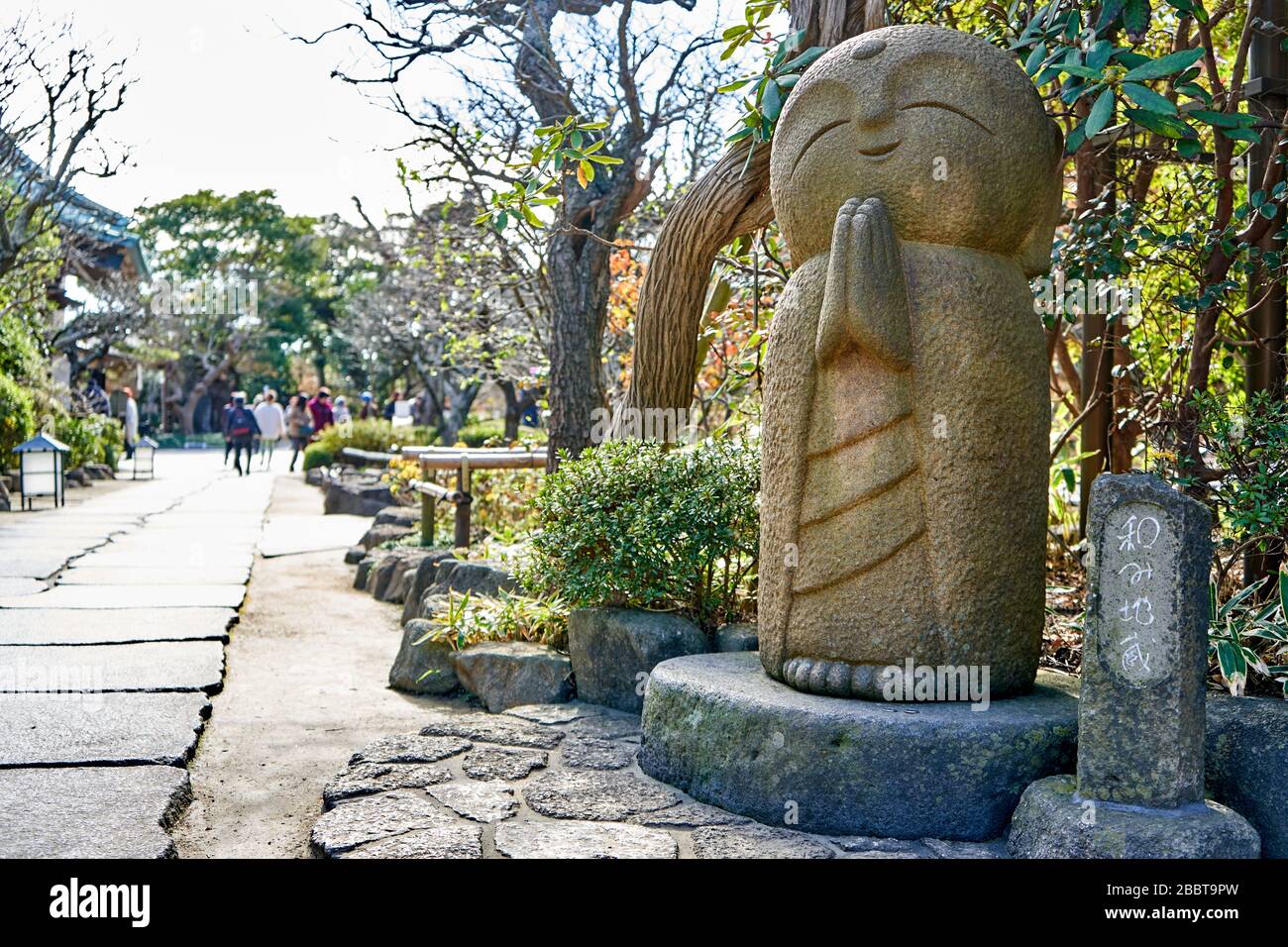 Smiling stone statue on temple grounds in Japan Stock Photo - Alamy