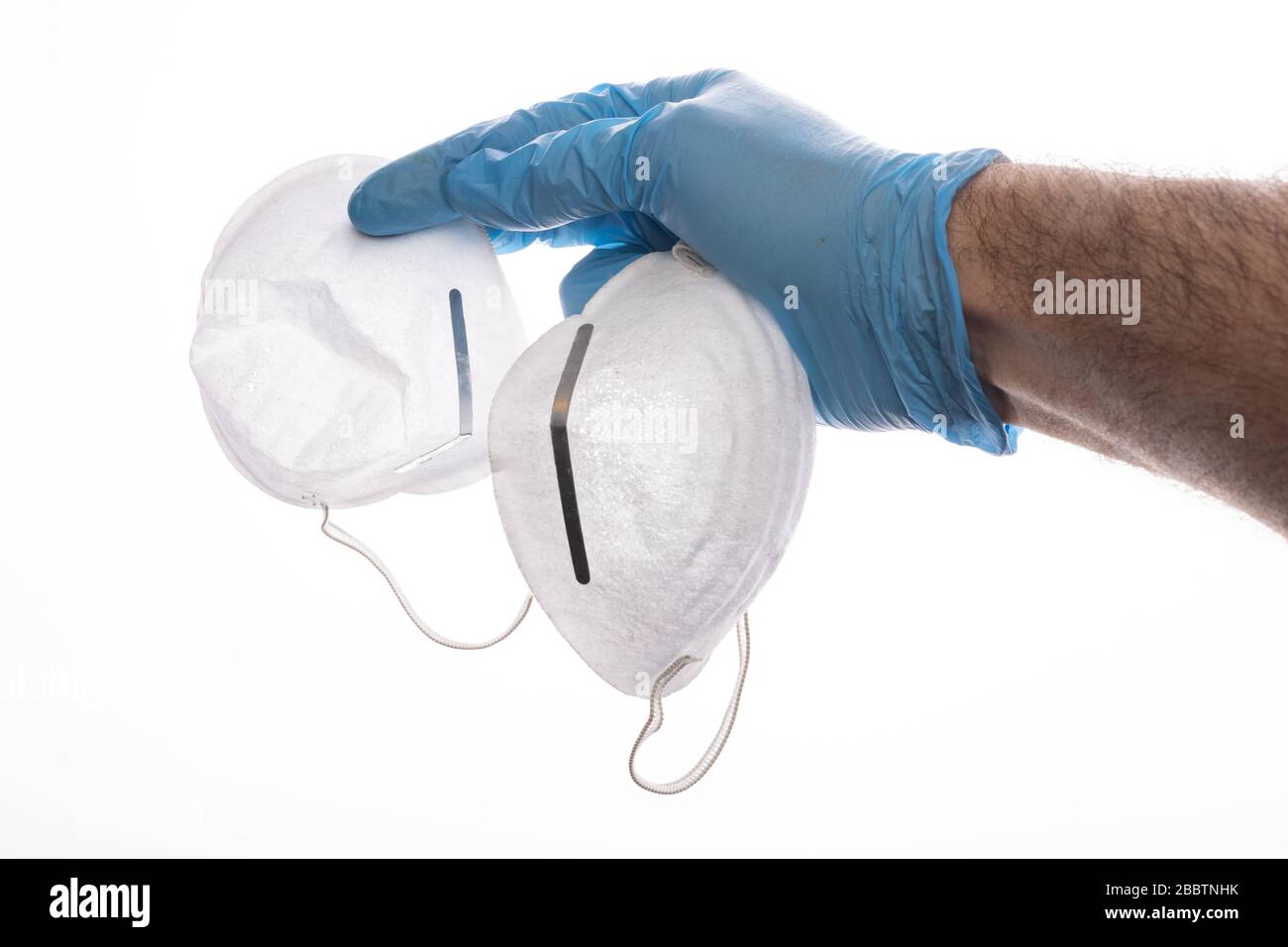 Men's hand in a blue latex glove holding masks. Hand and face ...