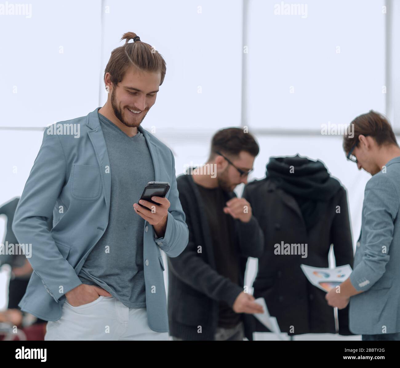 designer with mobile phone on background creative Studio Stock Photo ...