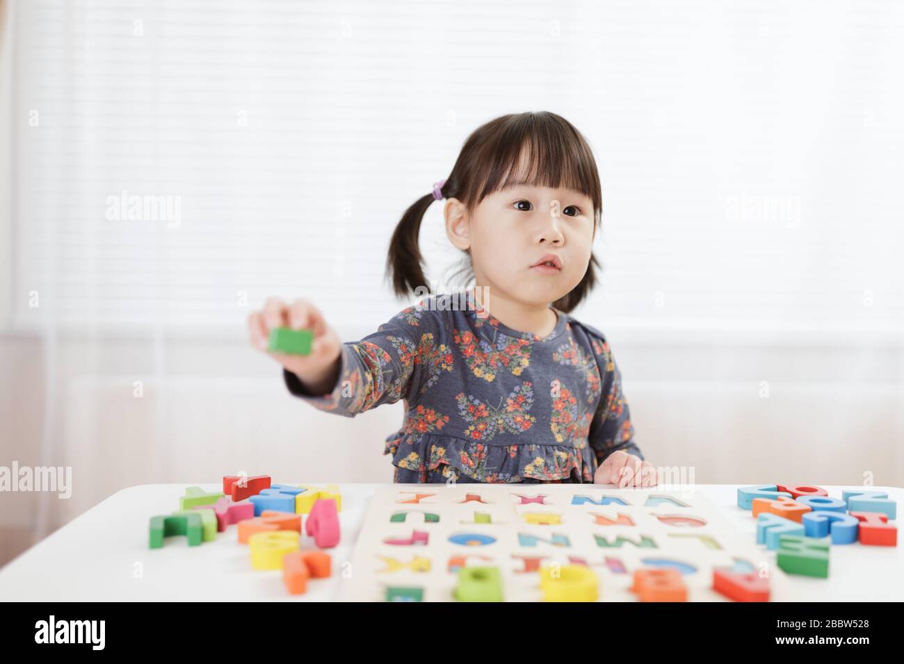 toddler girl learning letter blocks for homeschooling Stock Photo - Alamy