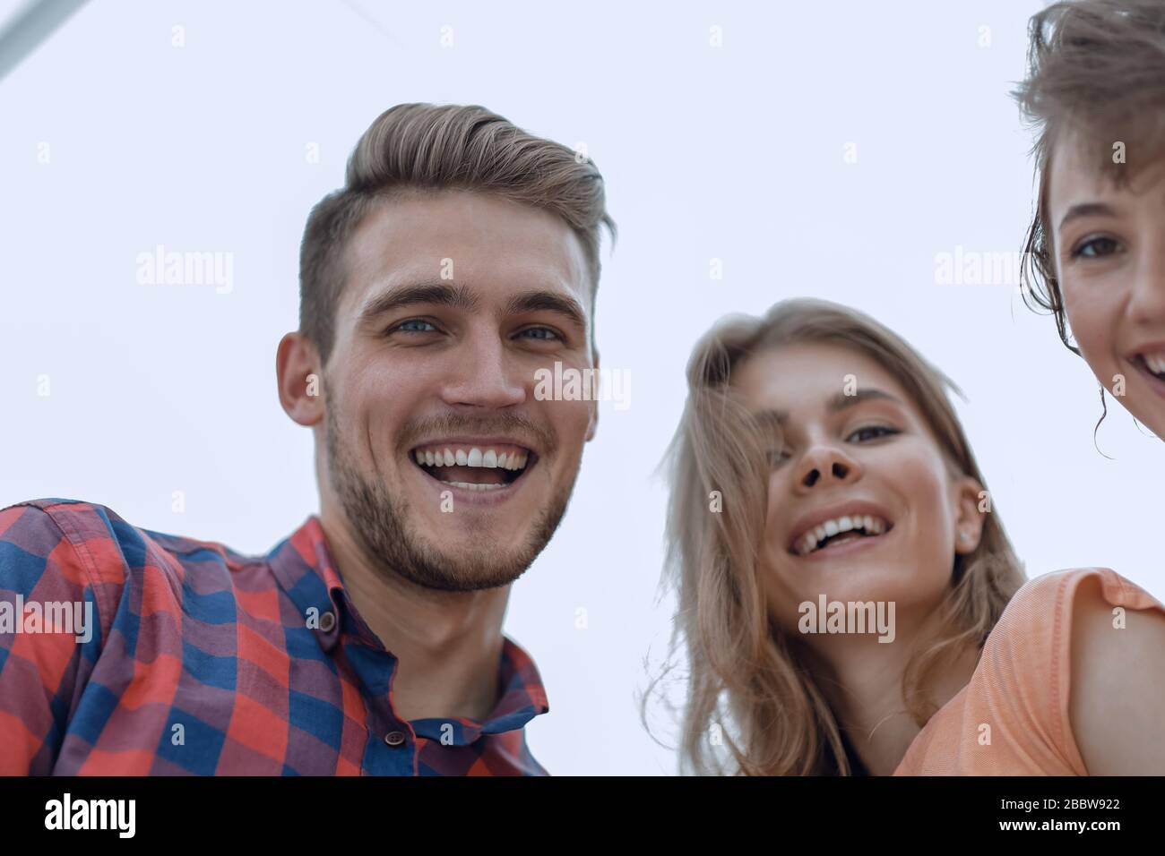 closeup of three young people smiling on white background Stock Photo ...
