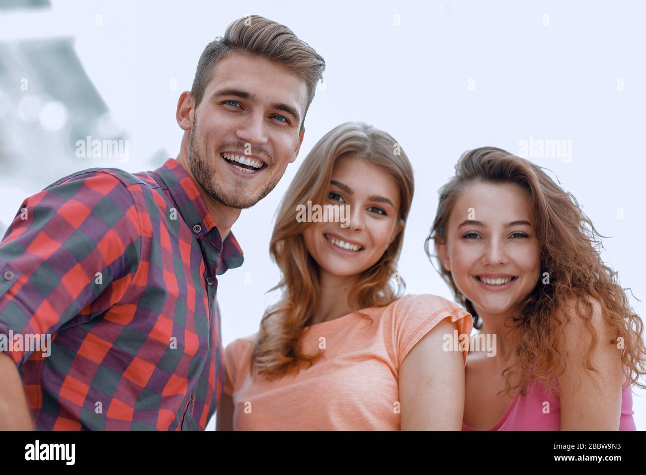 closeup of three young people smiling on white background Stock Photo ...