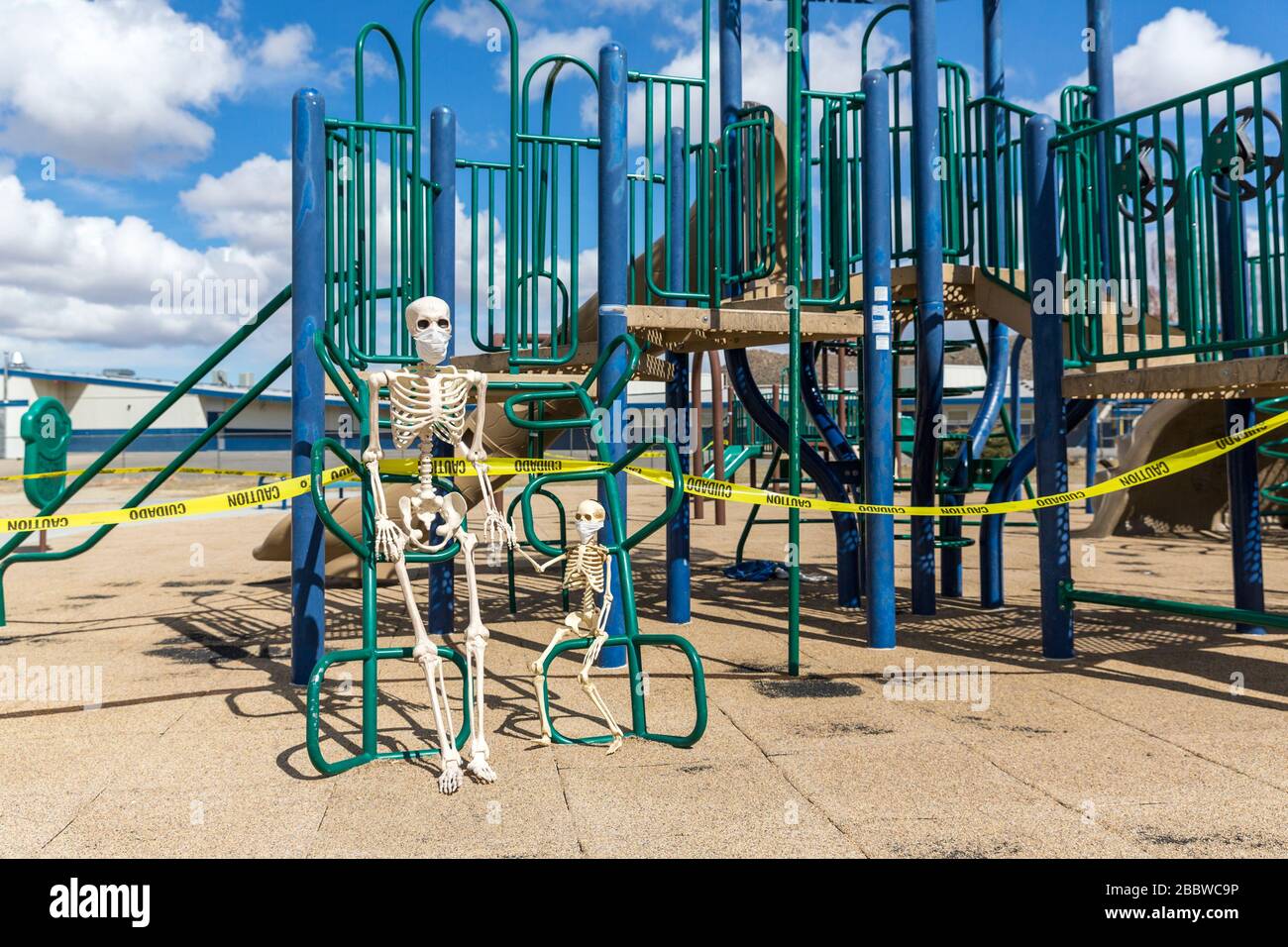 Adult and child skeletons holding hands sitting on playground equipment ...