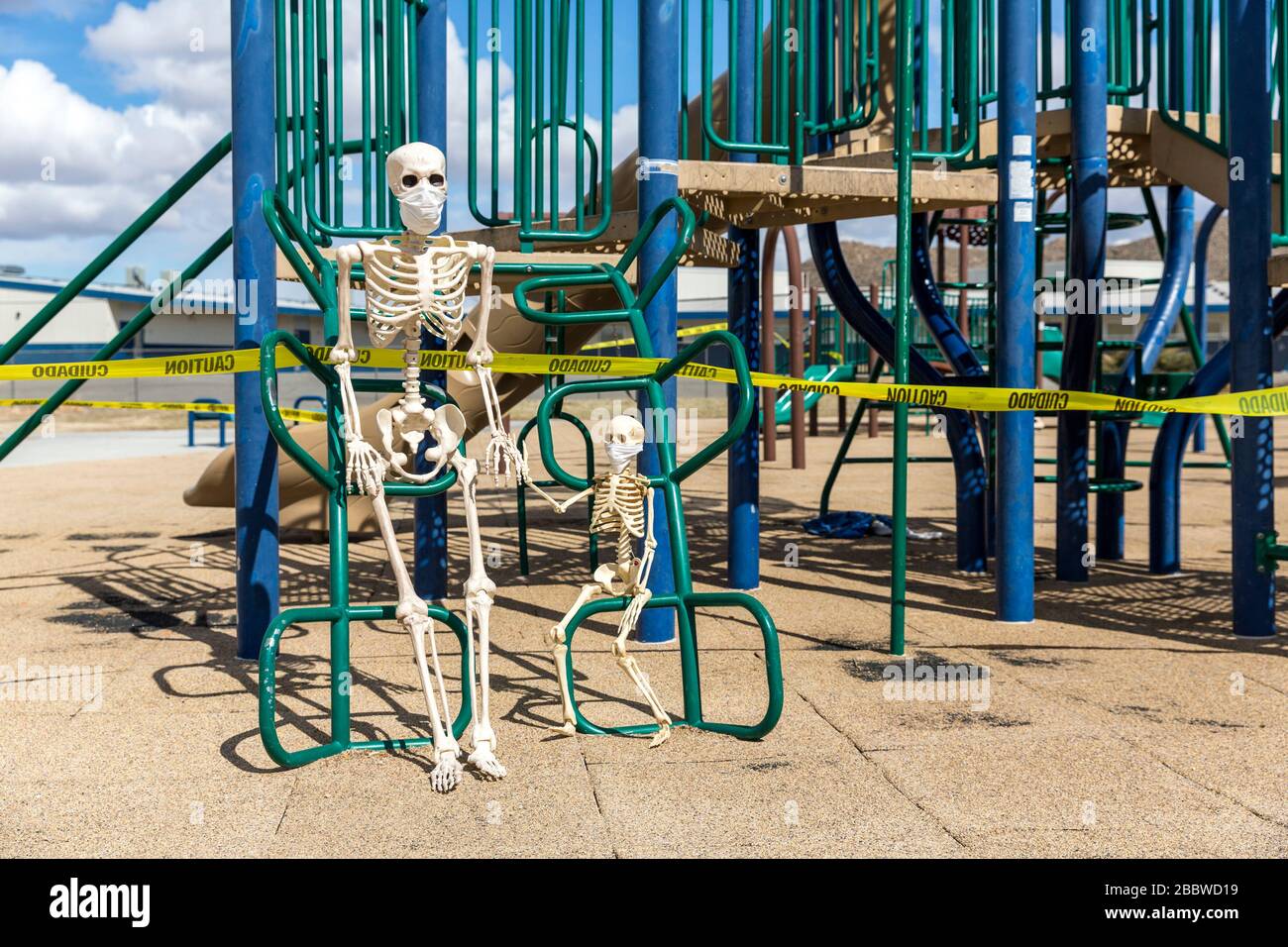 Adult and child skeletons holding hands sitting on playground equipment ...