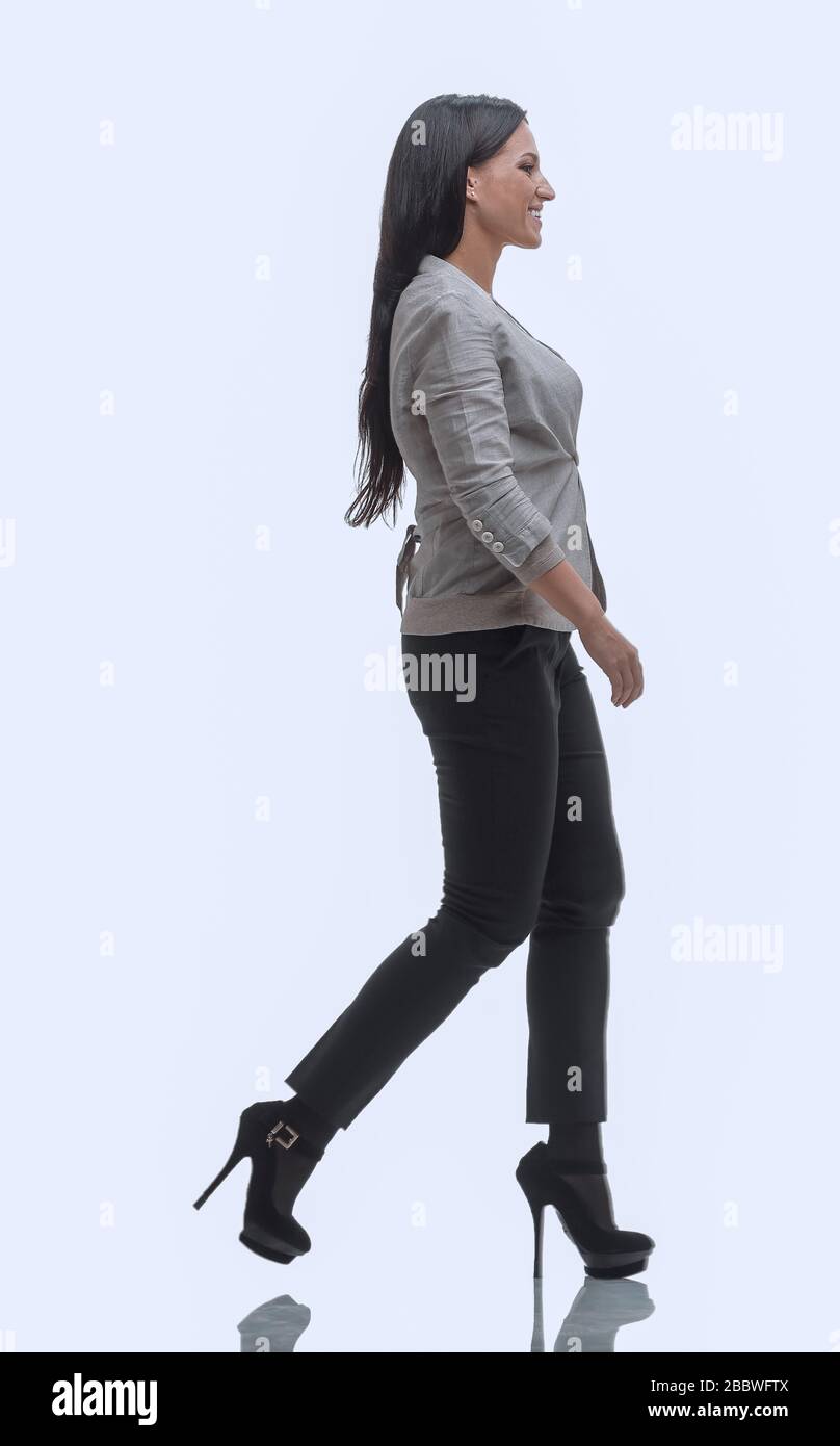 full-length. side view. modern young woman confidently goes forward ...