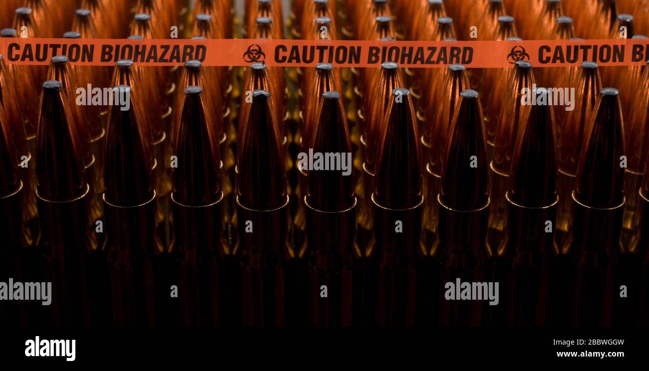 Rifle cartridges with a caution biohazard tape in between and room for ...