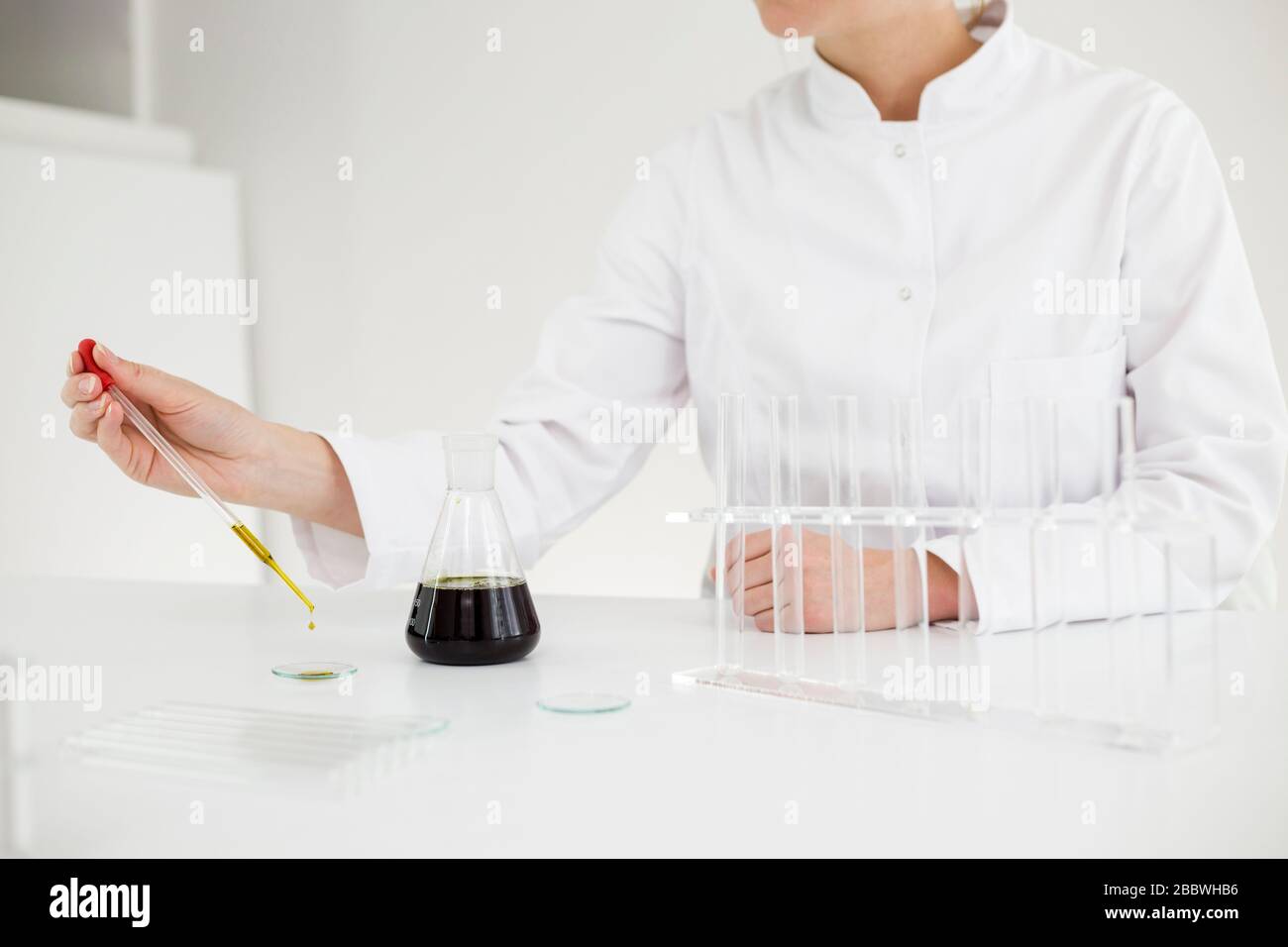 Female scientist with a glasses testing cbd oil extracted from a ...