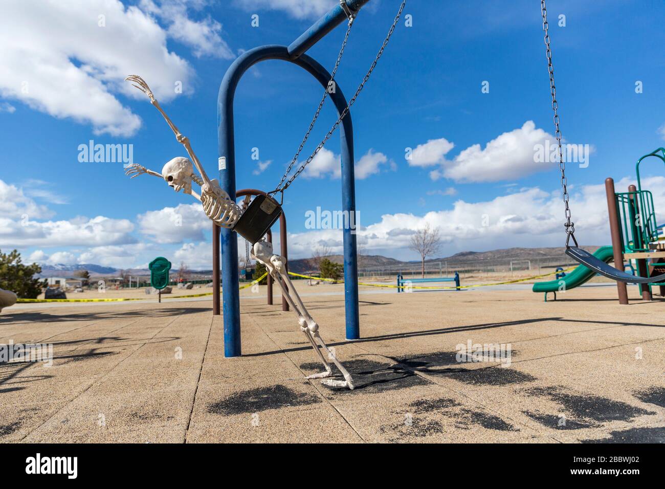 Skeleton playing superman on a child's swing in an empty park Stock ...